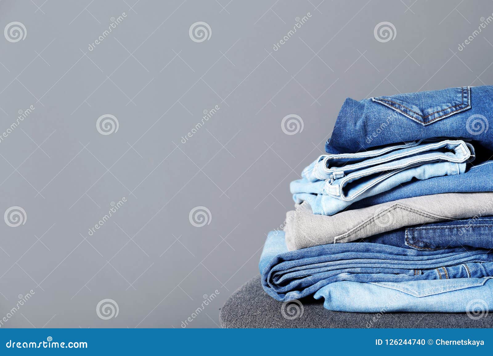 Stack of Different Jeans on Stool Stock Photo - Image of sale ...