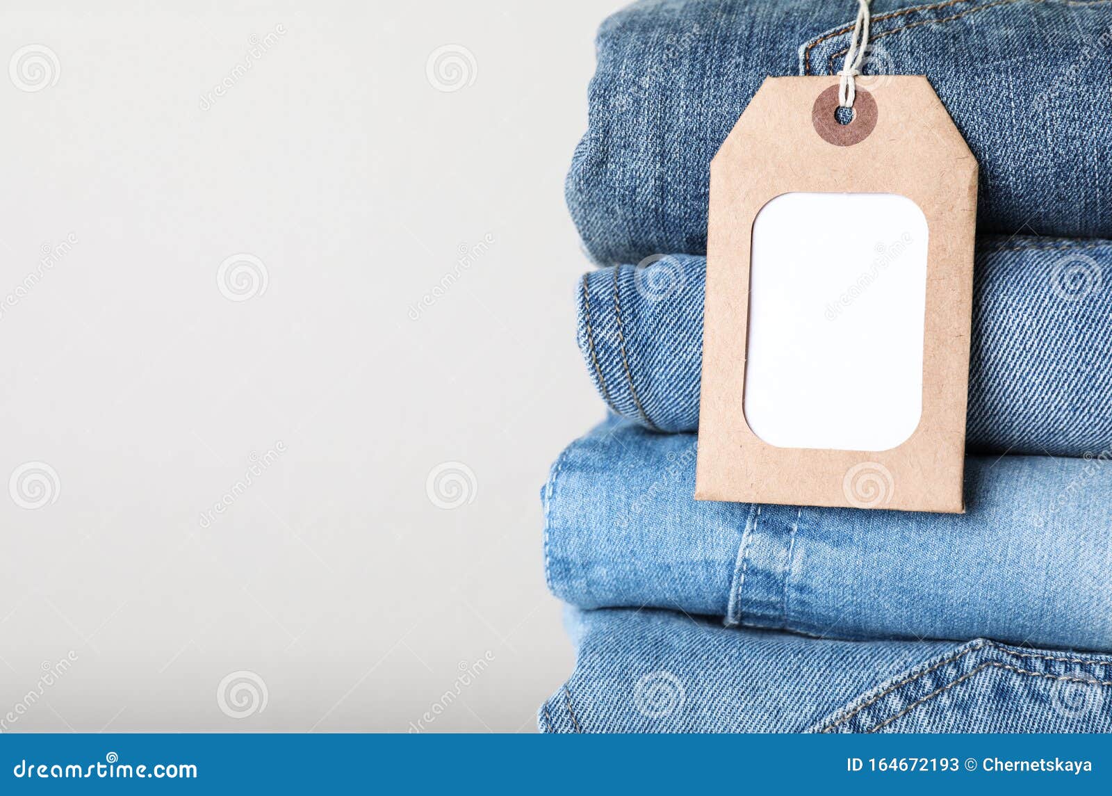 Stack of Different Jeans with Tag on Background, Closeup. Space for ...