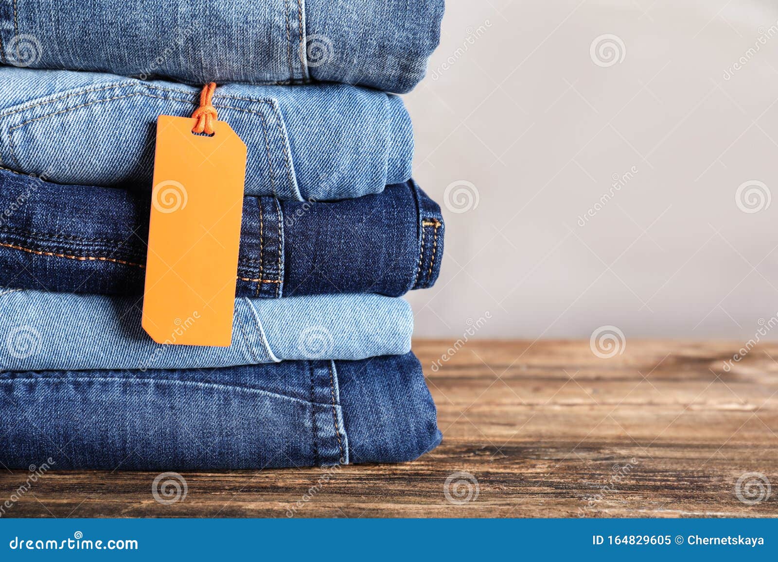 Stack of Different Jeans with Tag on Table. Space for Text Stock Image ...