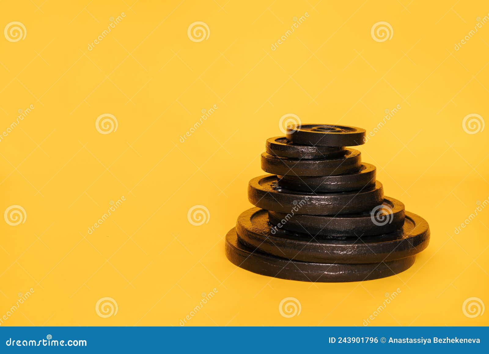 Stack of Discs of Different Weights on Yellow Background Stock Photo ...