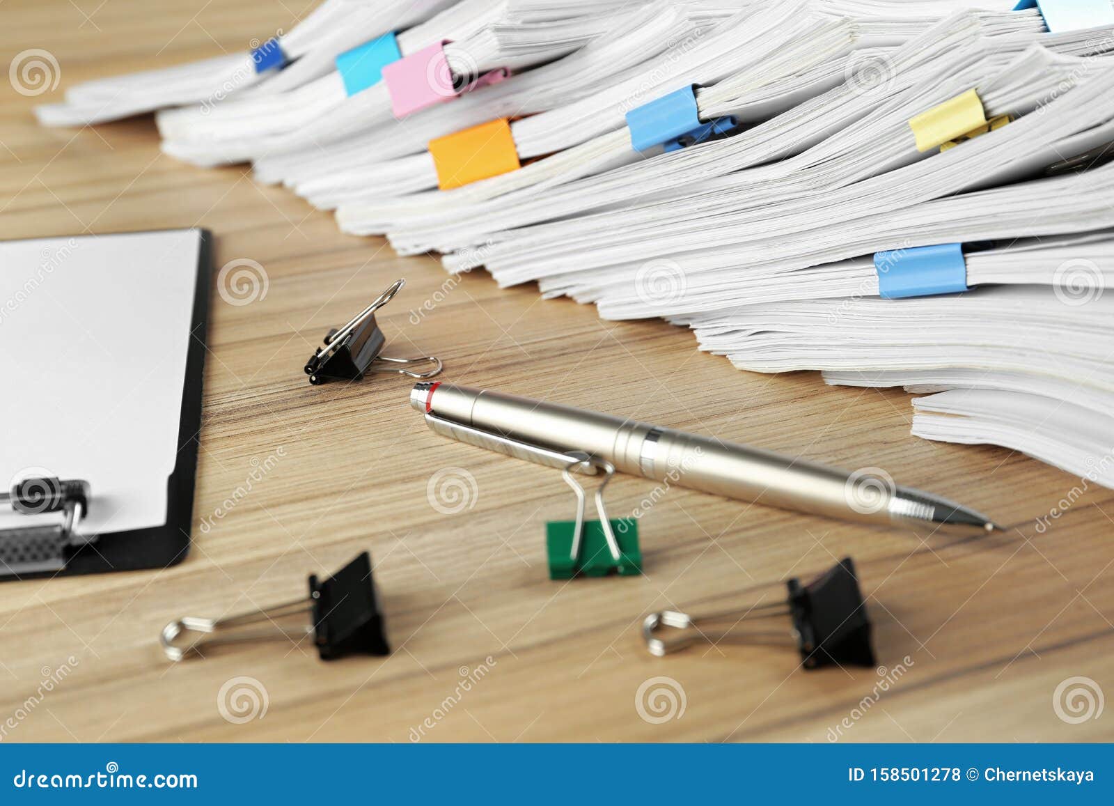 Stack of Documents with Binder Clips, Clipboard and Pen on Wooden Table ...