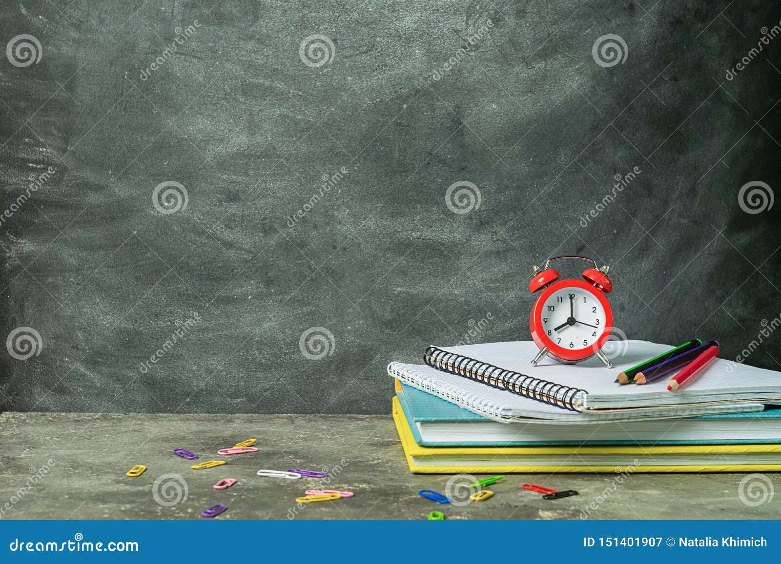 A Stack of Educational Notebooks of Books and a Red Alarm Clock on the ...