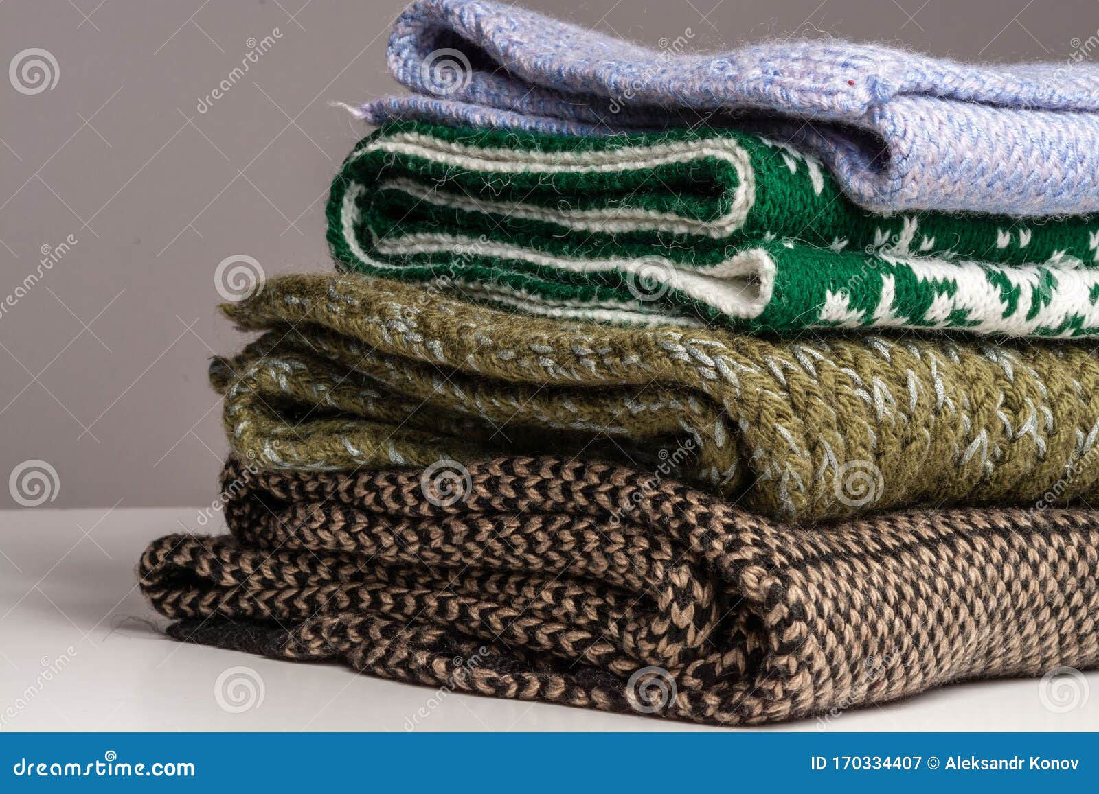 A Stack of Folded Scarves of Different Colors on a White and Gray ...