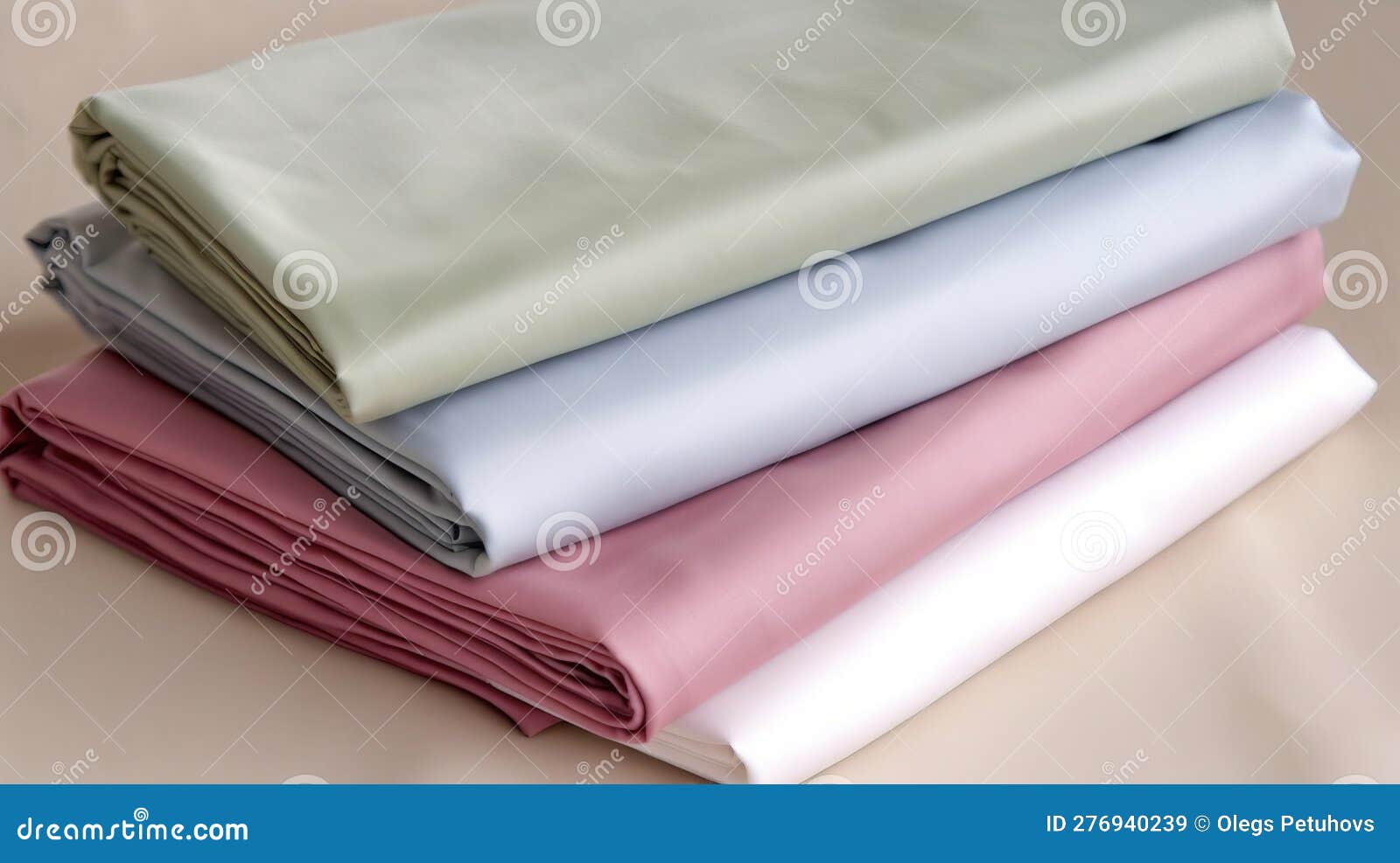 A Stack of Folded Sheets Sitting on Top of Each Other on Top of a Bed ...