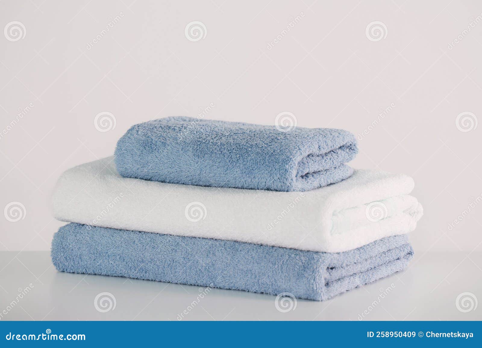 Stack of Folded Towels on White Table Stock Image - Image of cotton ...