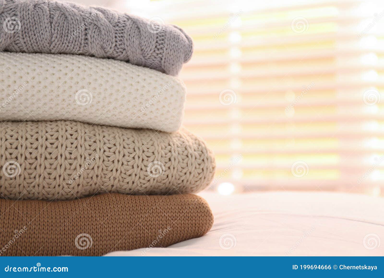 Stack of Folded Warm Sweaters on Bed Indoors, Closeup. Space for Text ...