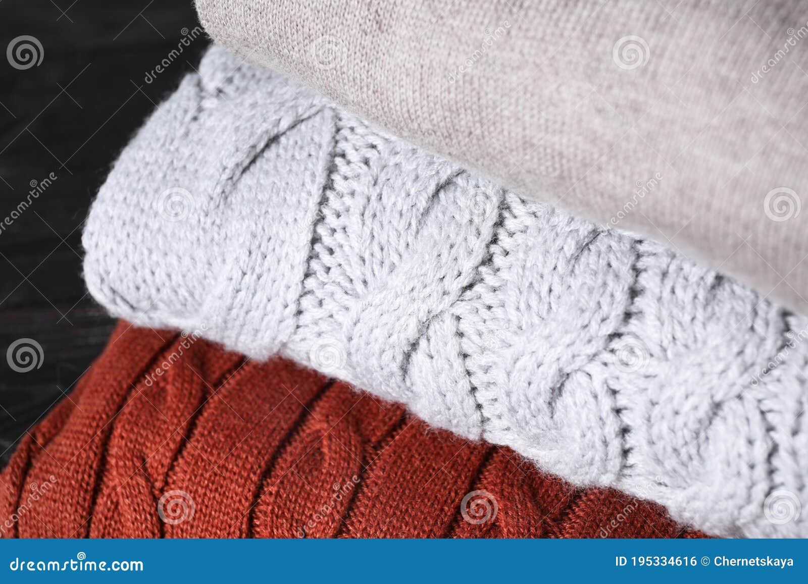 Stack of Folded Warm Sweaters on Black Table, Closeup Stock Photo ...