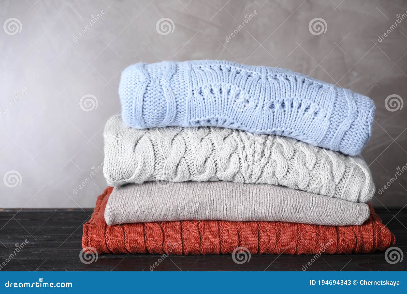 Stack of Folded Warm Sweaters on Black Table Stock Image - Image of ...