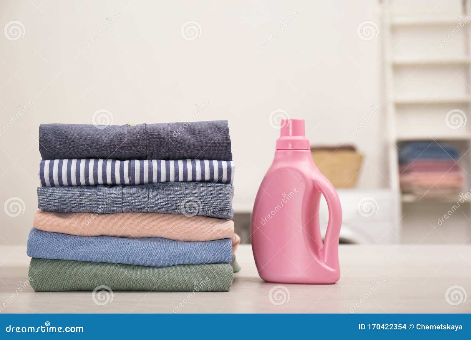 Stack of Fresh Laundry and Detergent on Table in Bathroom Stock Photo ...