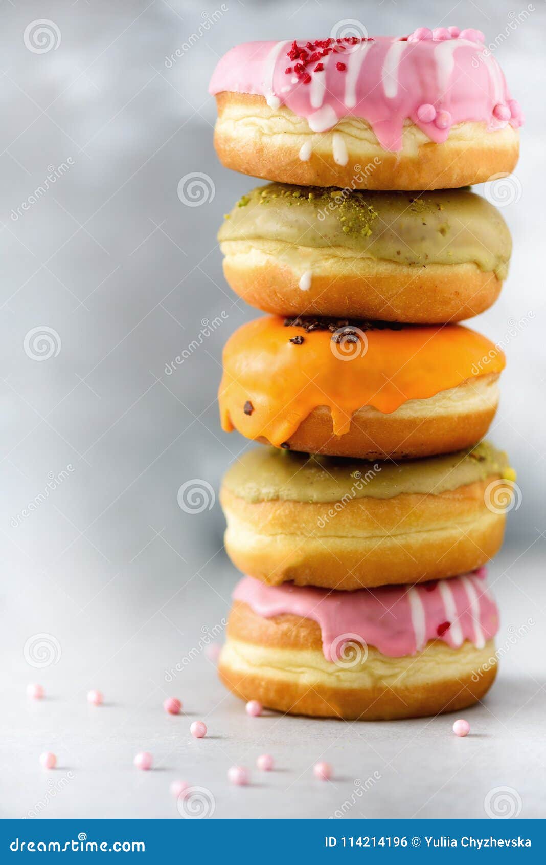 Stack of Glazed Colorful Assorted Donuts with Sprinkles on Grey Cement ...