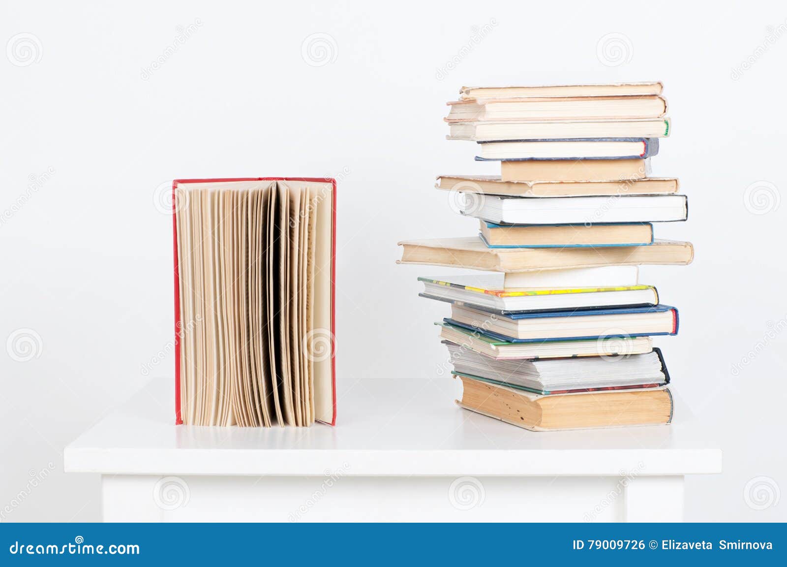 Stack of Hardback Books and Old Open Book on White Wall Background ...