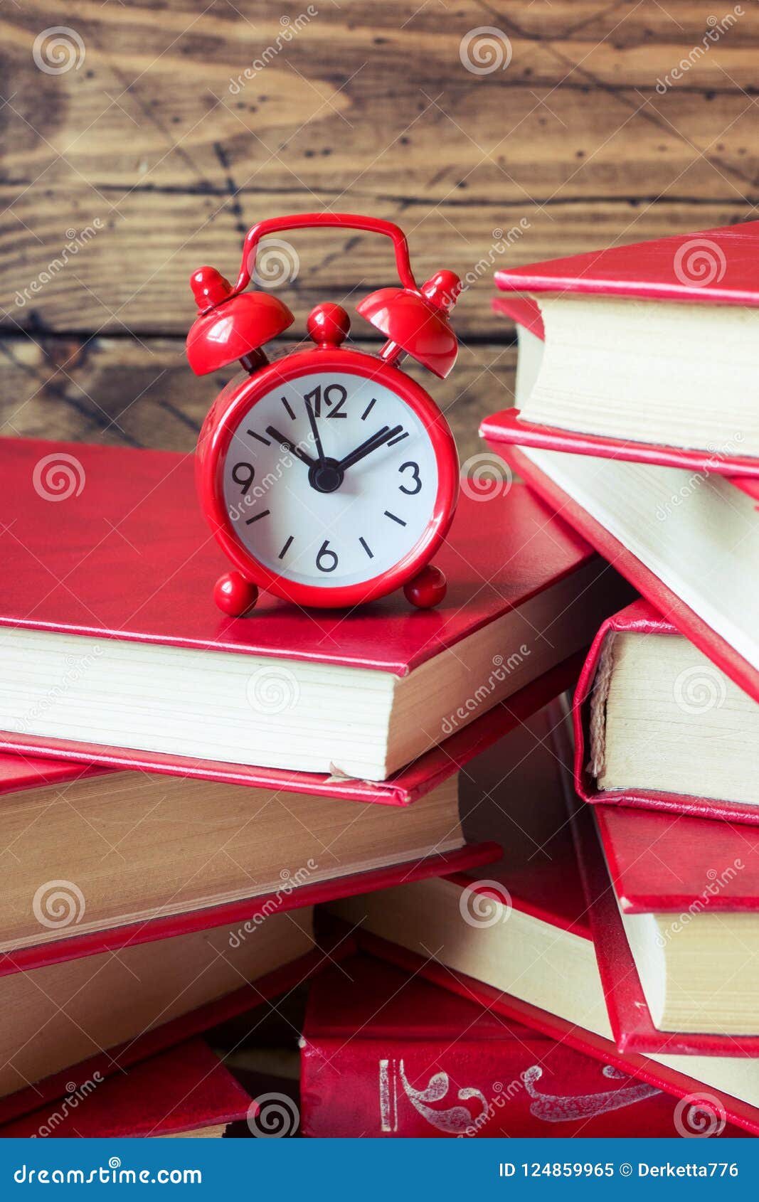 A Stack of Hardcover Books and an Alarm Clock on a Wooden Table. Copy ... A Stack of Hardcover Books and an Alarm Clock on a Wooden Table. Copy ...