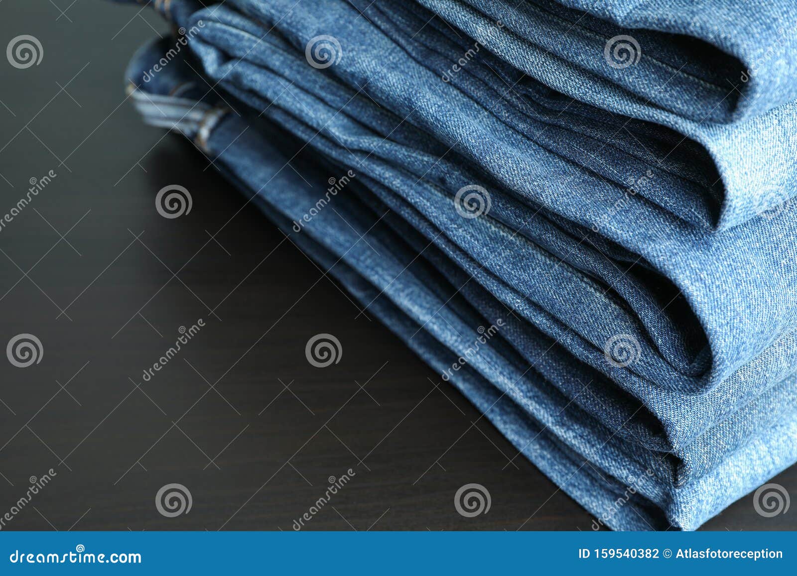 Stack of Jeans Pants on Black Table Stock Photo - Image of light ...