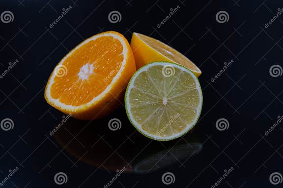 Stack of Lime, Orange and Lemon Halves on a Isolated Black Background ...