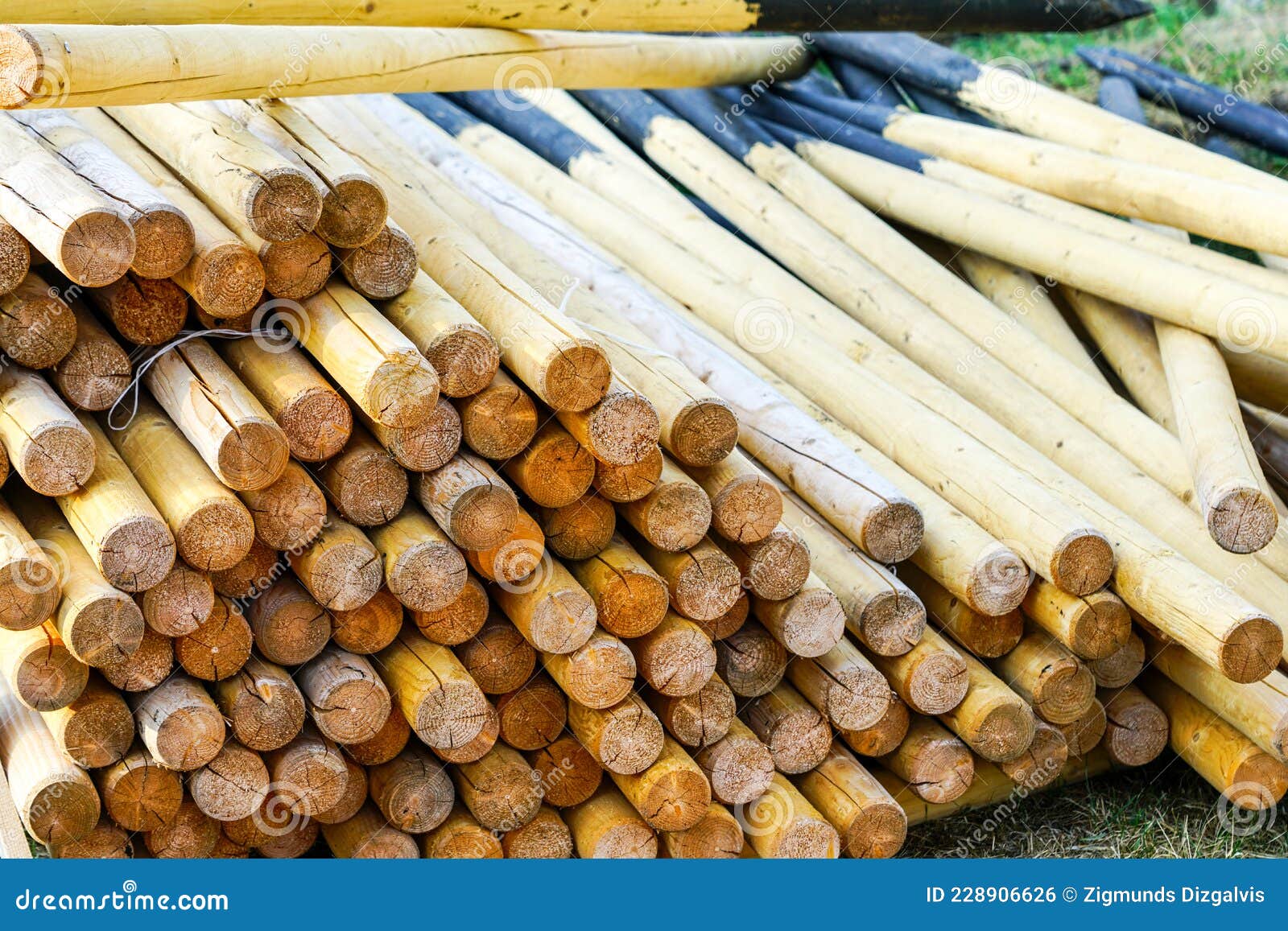 Stack with Long Round Natural Wooden Fence Posts with Tarred and ...