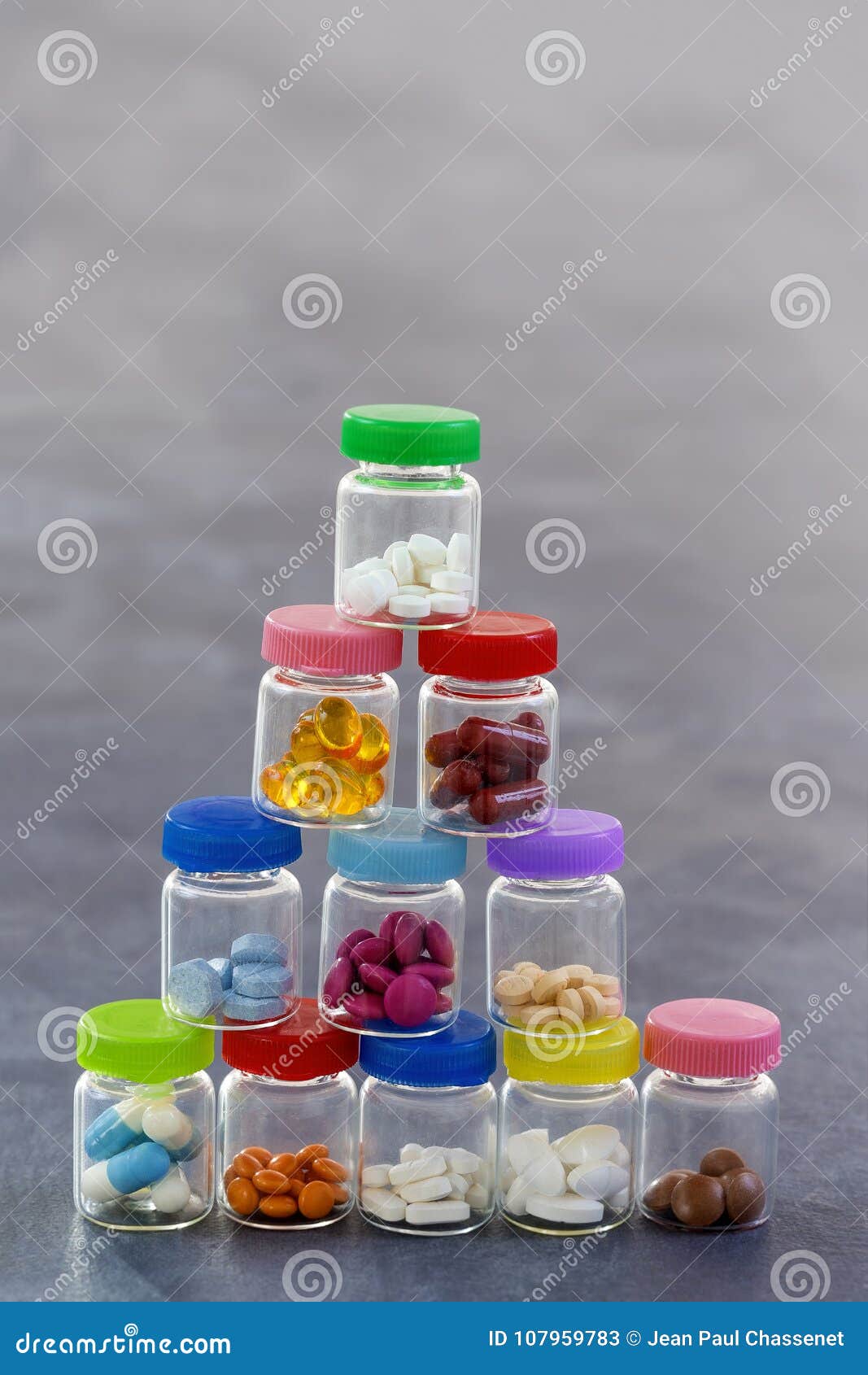 Stack of Medicine Tablets in Glass Box with Multi Colored Plastic Caps ...