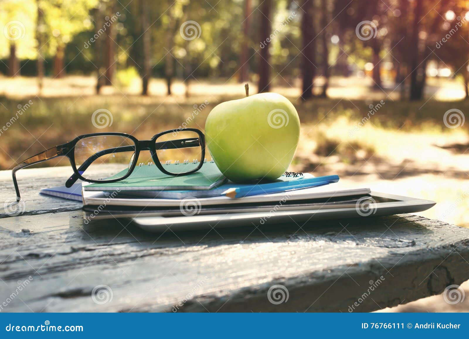 Stack Notebook, Apple and Glasses on Bench in a Park Stock Image ...