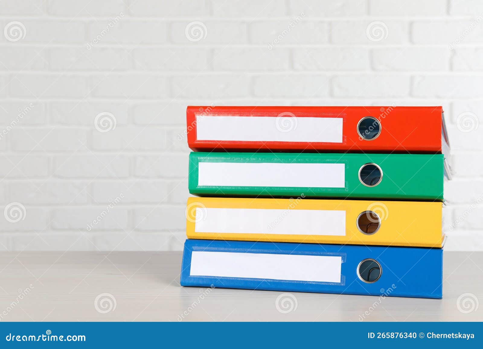 Stack of Office Folders on Wooden Table Near White Brick Wall, Space ...