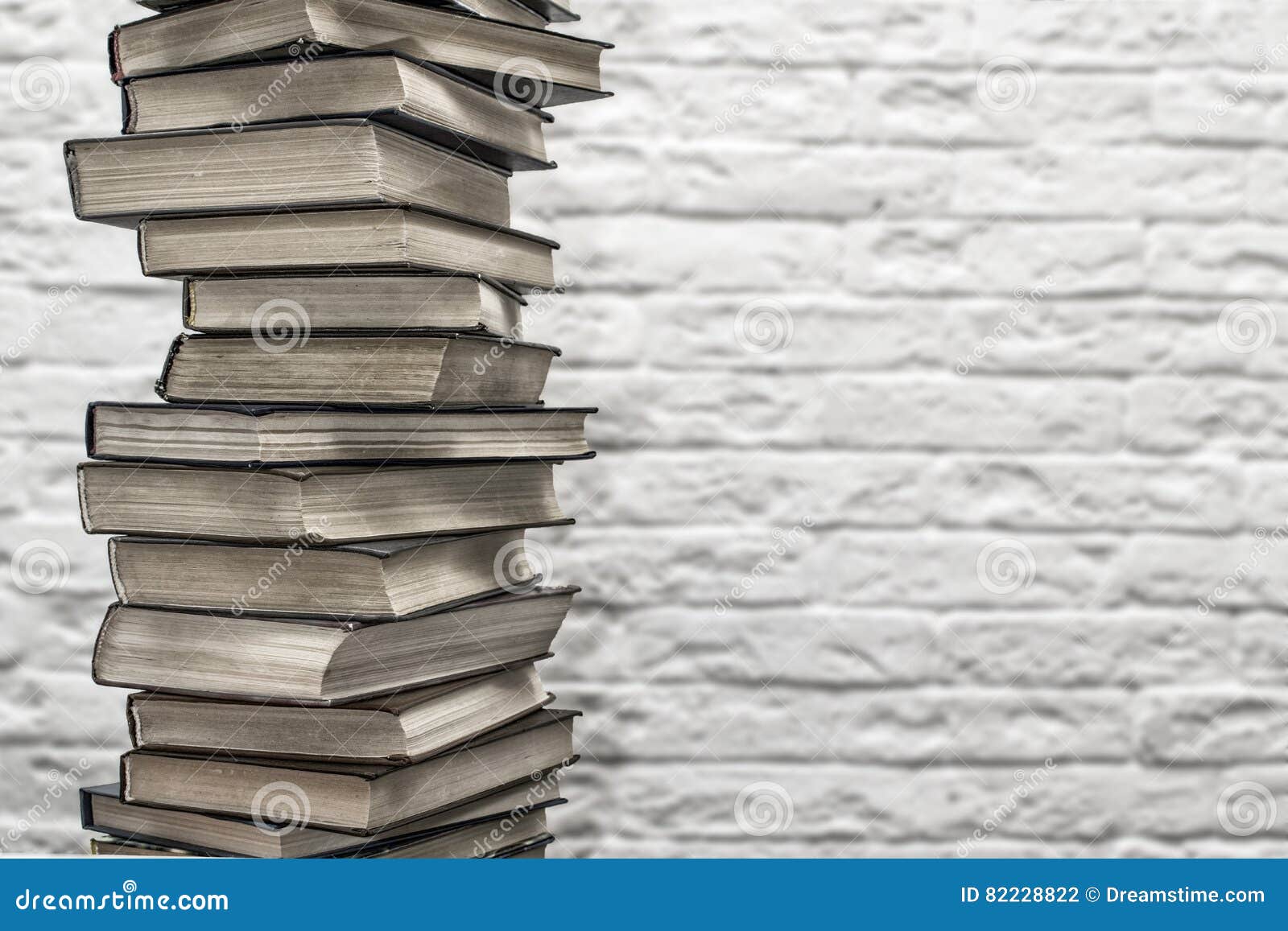A Stack of Old Books on the Background of Brick Wall Stock Photo ...