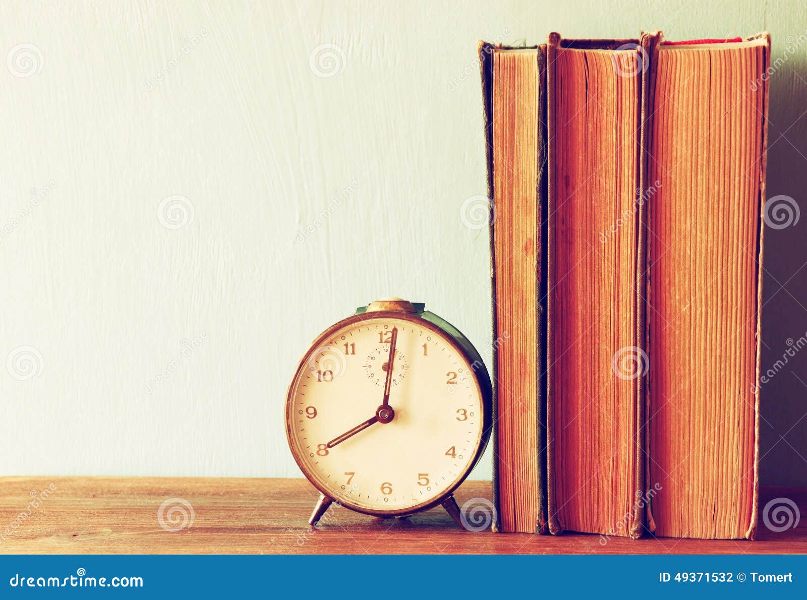 Stack of Old Books and Old Clock Over Wooden Table . Filtered Image ...