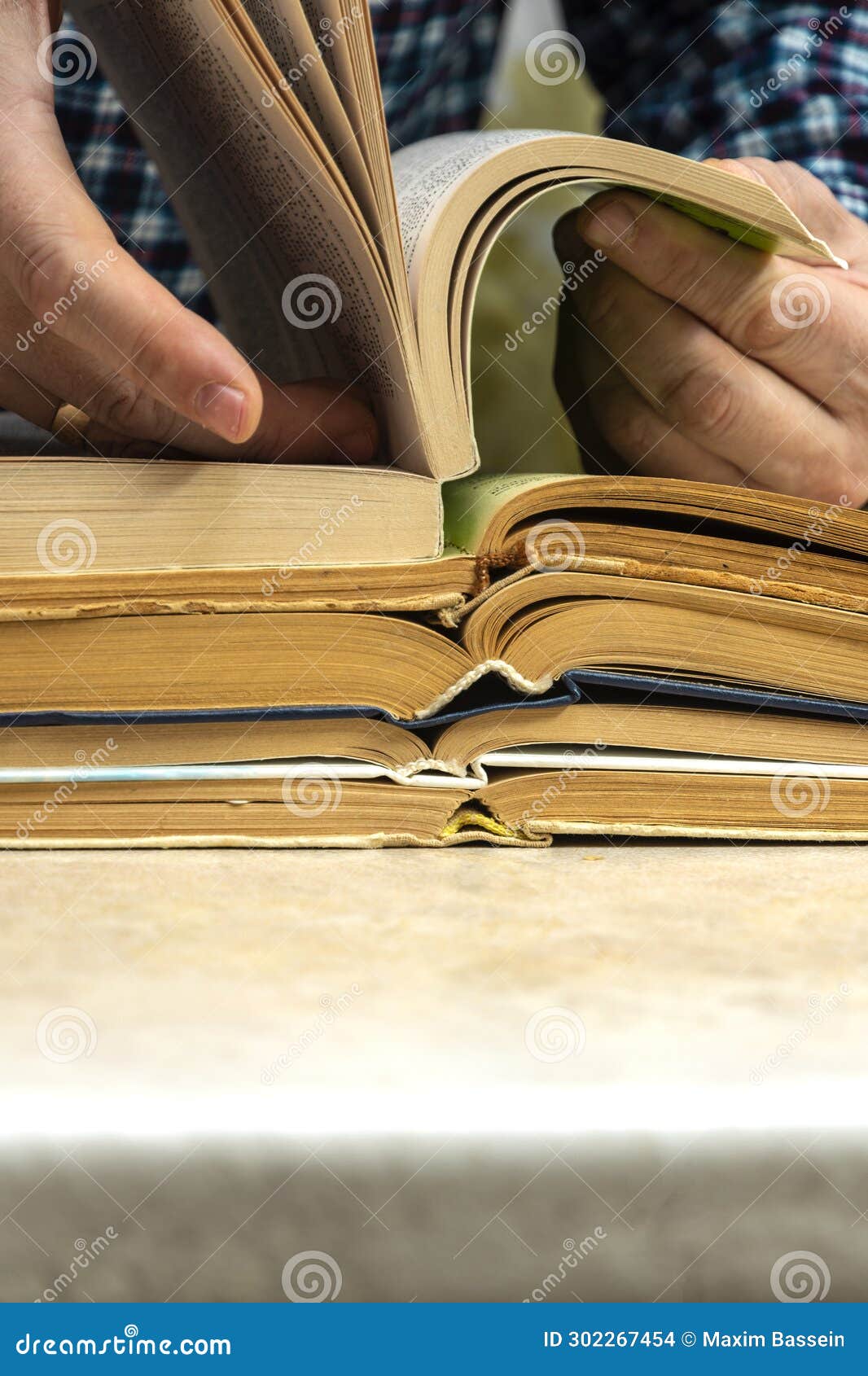 A Stack of Old Books Open and a Hand Flipping through the Pages Stock ...