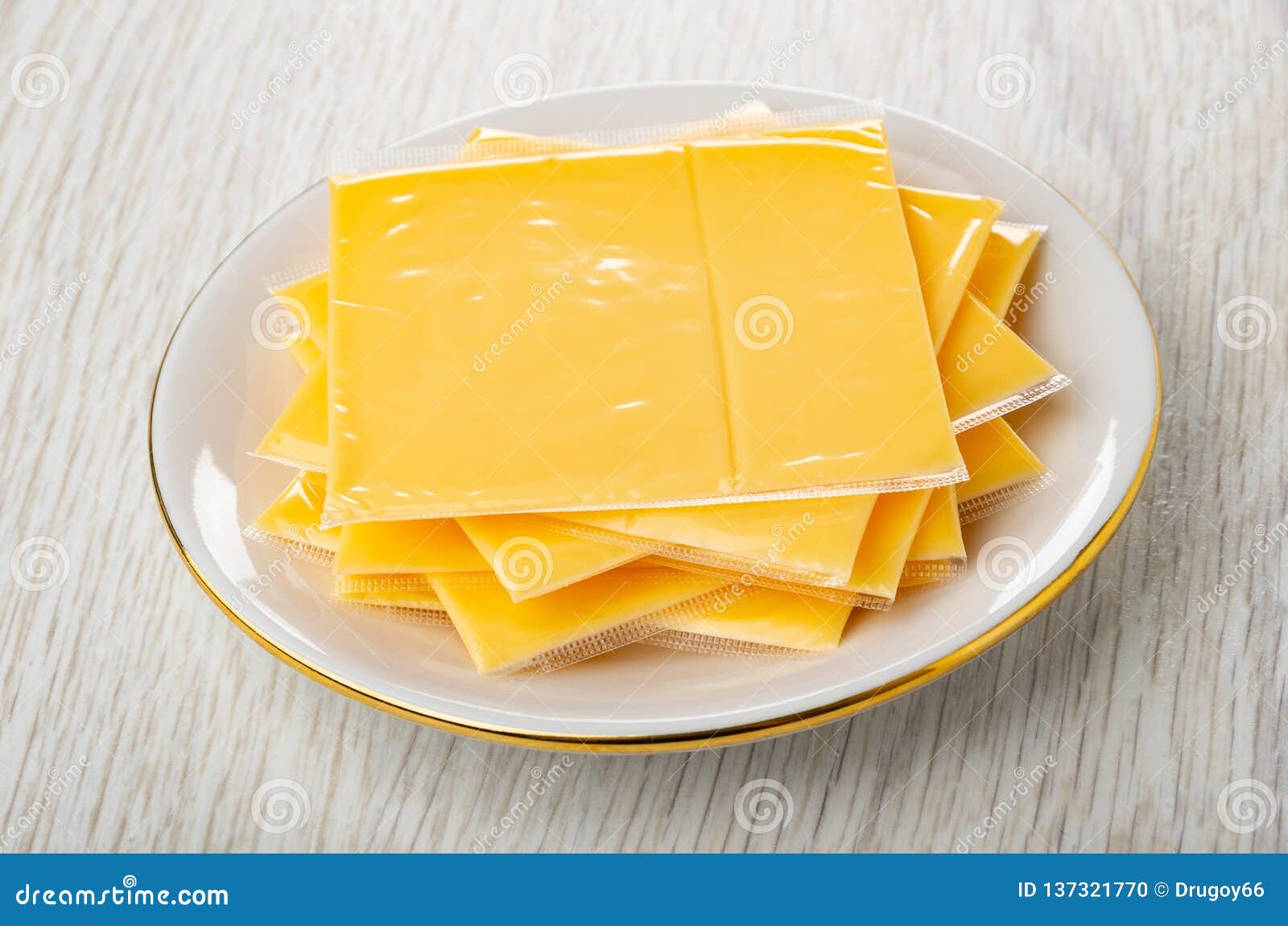 Stack of Packages of Cheese in Saucer on Wooden Table Stock Photo ...