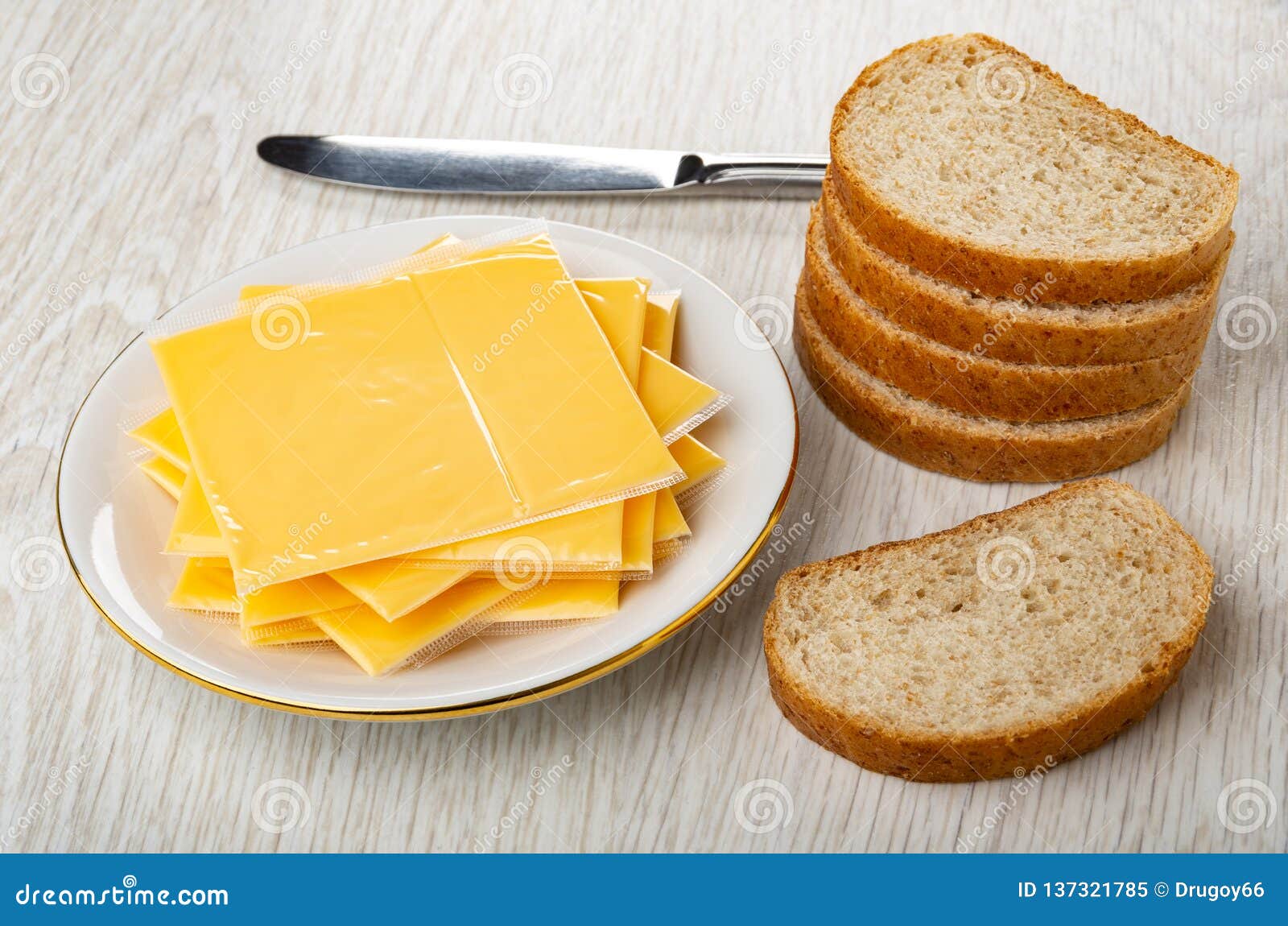 Stack of Packages of Cheese in Saucer, Knife, Pieces of Bread on Table ...