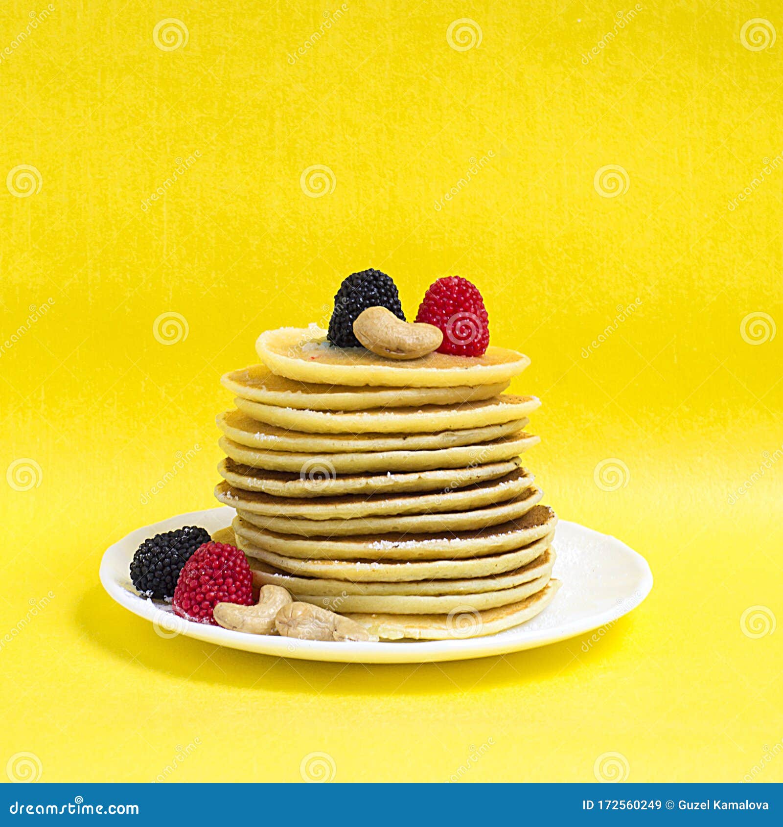 Stack of Pancakes with Powdered Sugar and Berries on a Yellow ...