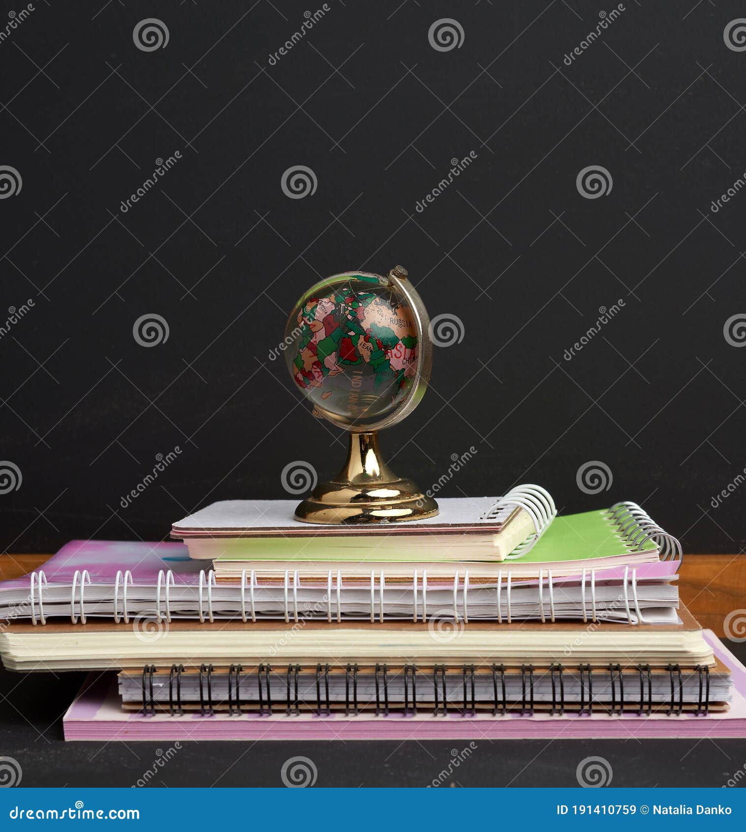 Stack of Paper School Notebooks and Glass Globe on Black Chalk Board ...