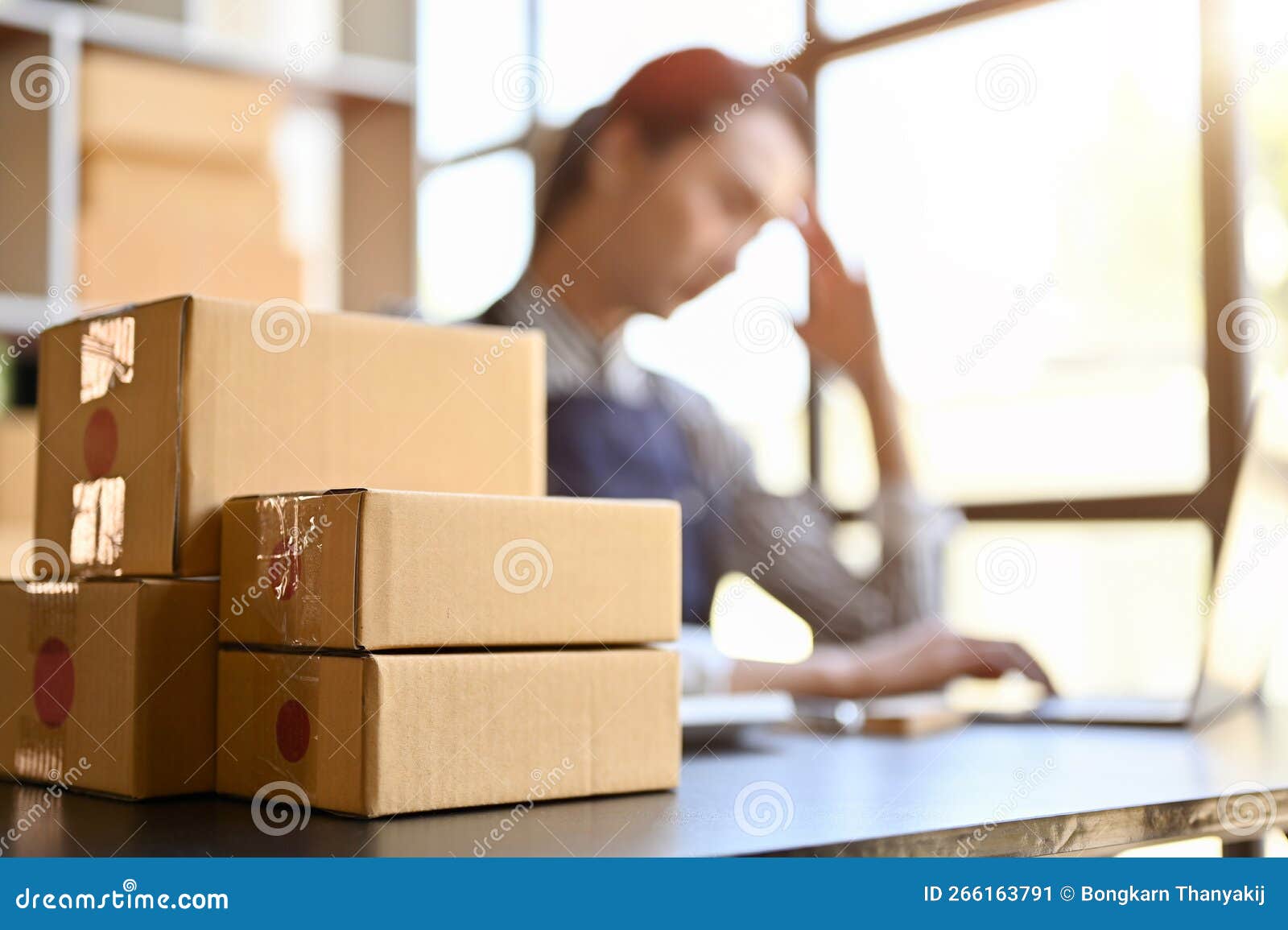 Stack of Parcel Boxes on the Table Over Blurred Background of a Female ...