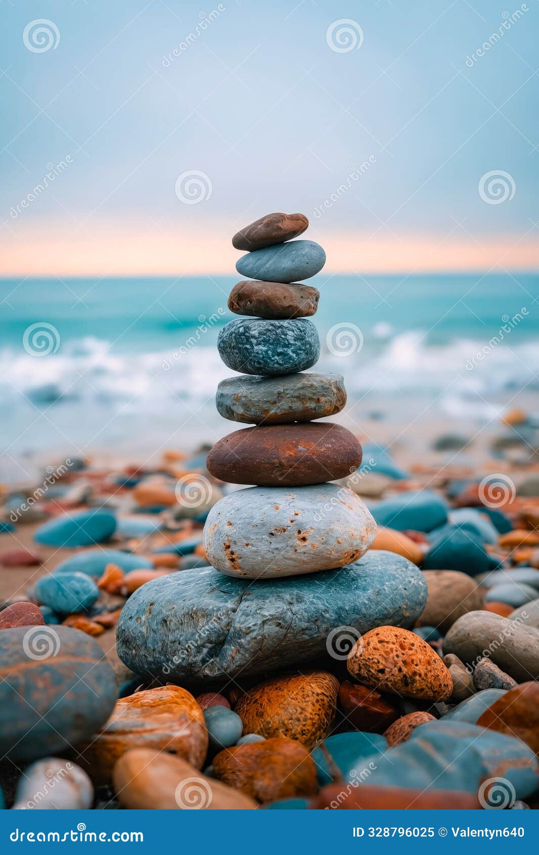 A Stack of Pebbles on a Rocky Beach with the Ocean in the Background ...