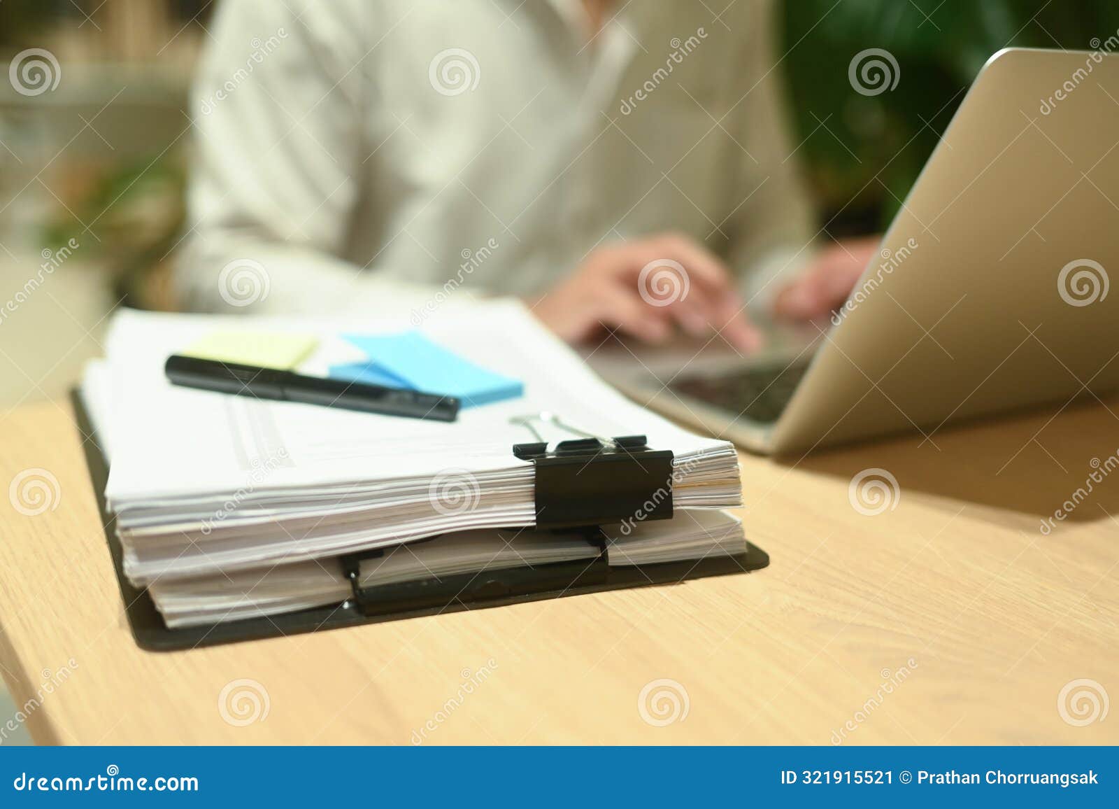 Stack of Report Paper Documents on Wooden Table with Businessman Using ...