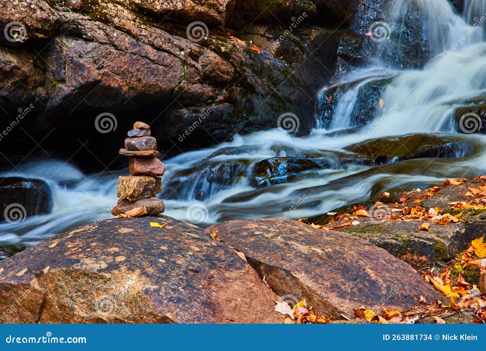 Stack of Rocks Cairn on Edge of Cascading River with Fall Leaves Stock ...