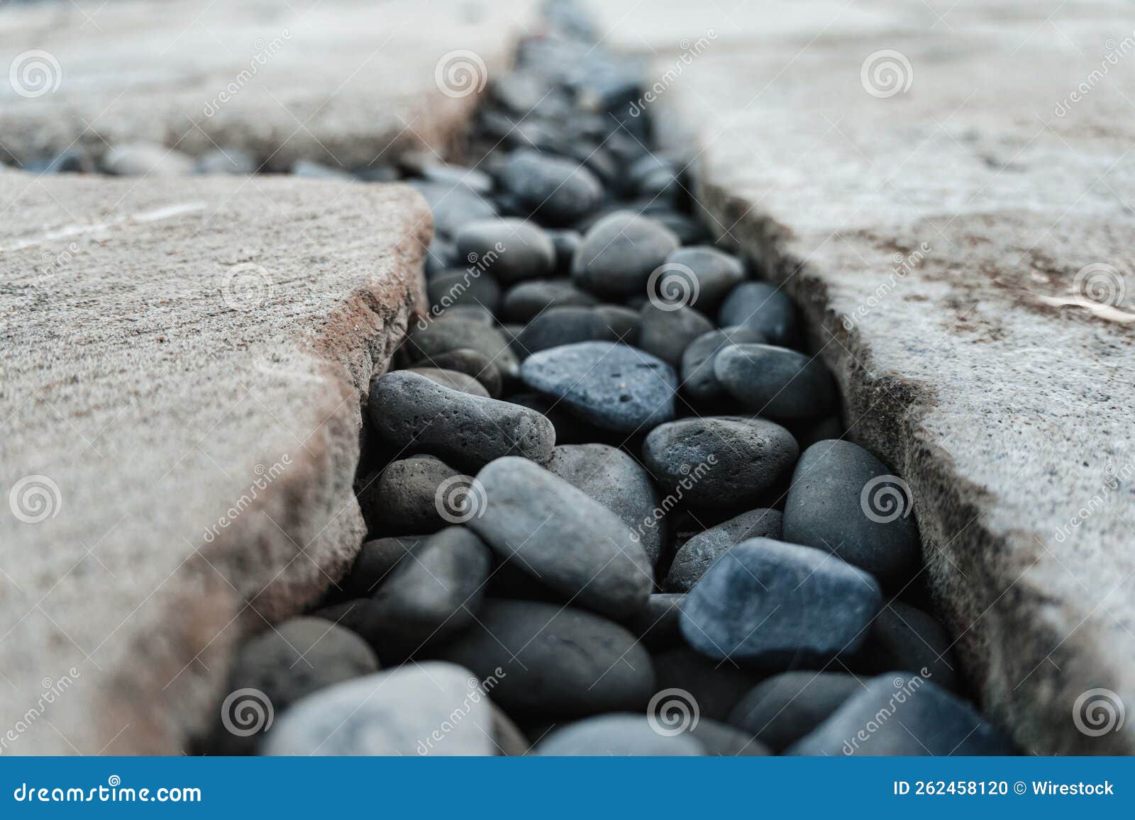 Stack of Rocks in between Concrete Pavers Stock Photo - Image of nature ...