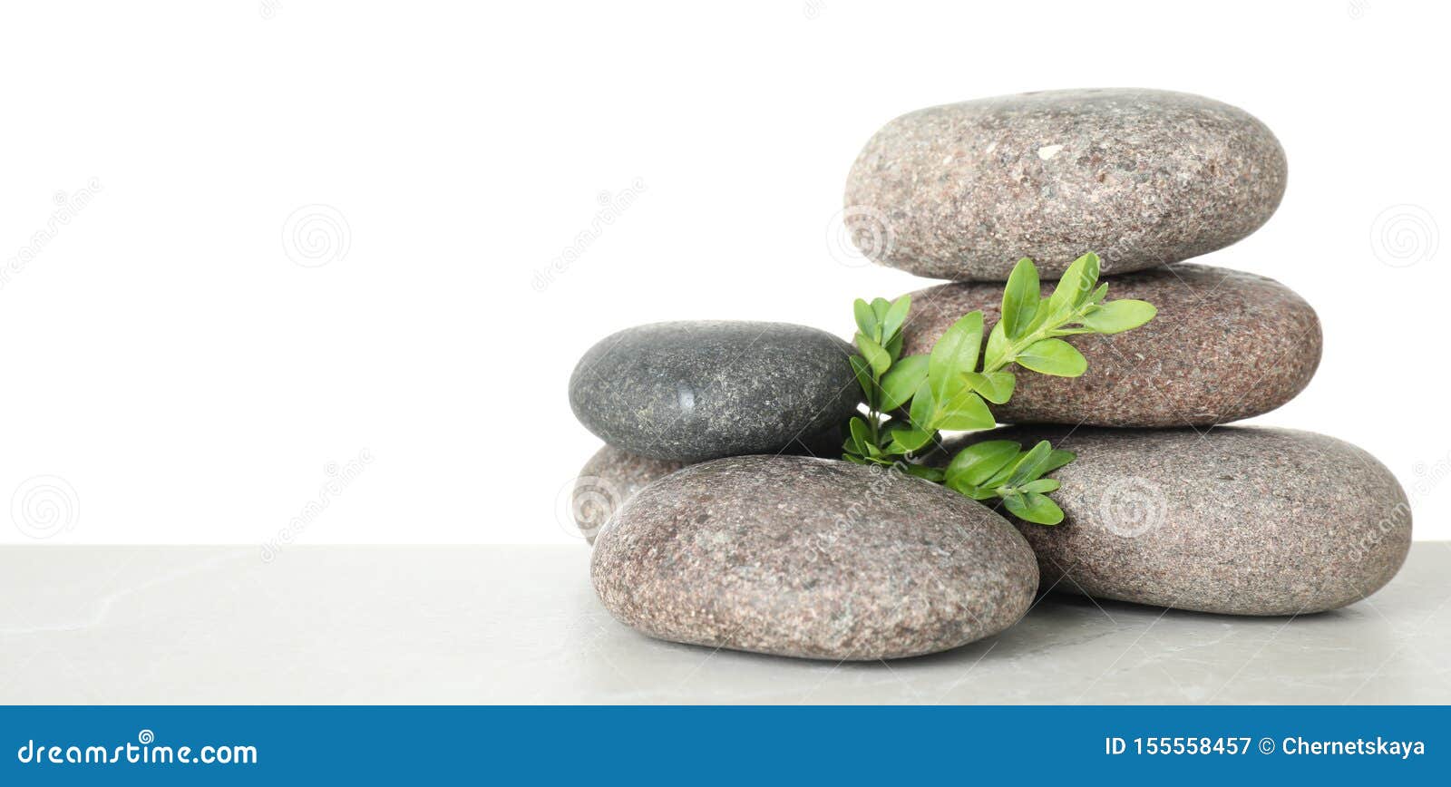 Stack of Spa Stones and Leaves on Table Against White . Space for Text ...