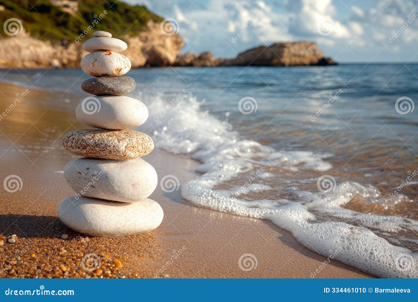 Stack of Stones Balanced on a Beach with Ocean Waves and a Coastline in ...
