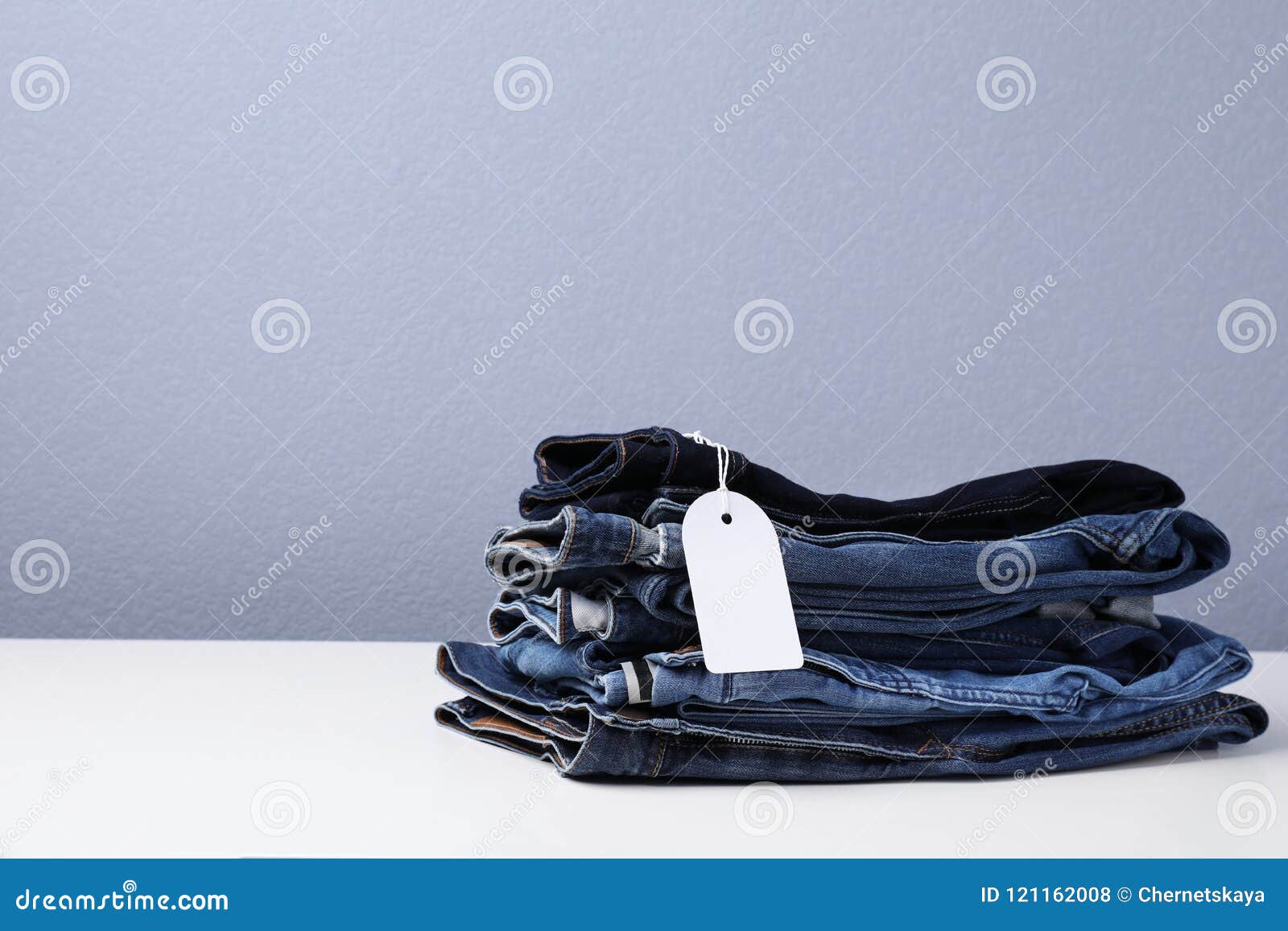 Stack of Stylish Jeans with Tag Stock Photo - Image of garment, space ...
