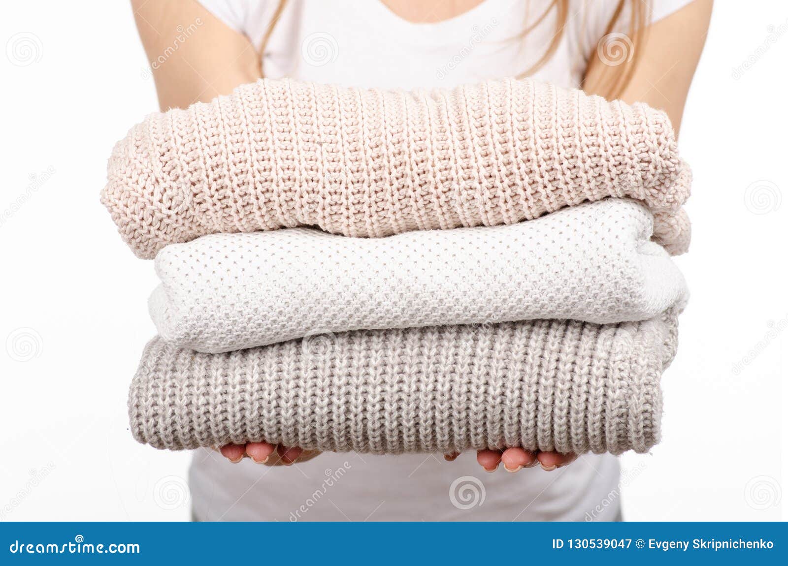 A Stack of Sweaters in the Hands of a Woman Stock Image - Image of ...