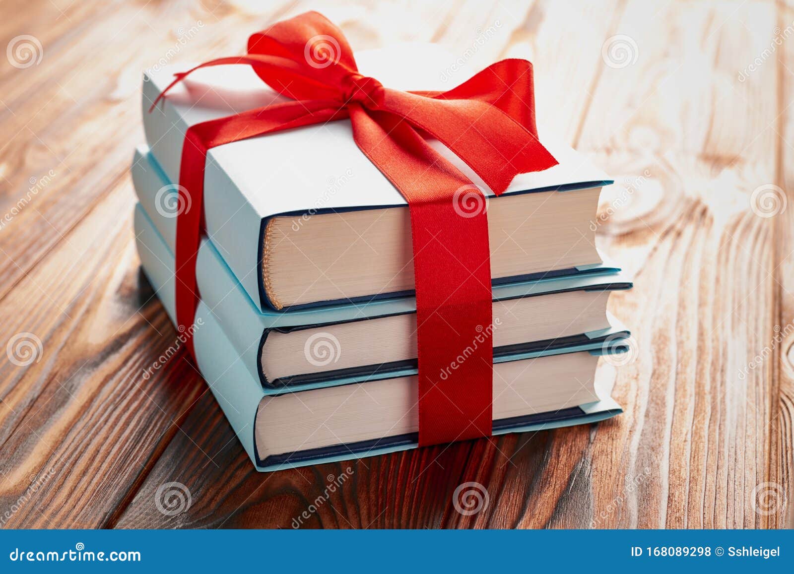 Stack of Three Books Tied with a Red Ribbon with a Bow on a Wooden ...