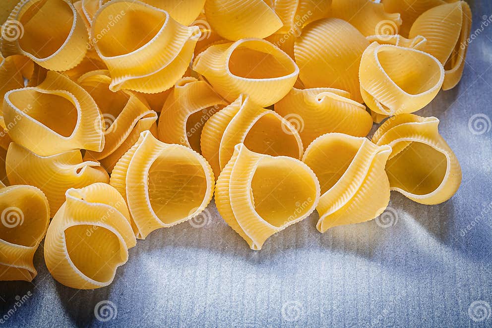 Stack of Uncooked Shell Macaroni on Blue Background Food and Dri Stock ...