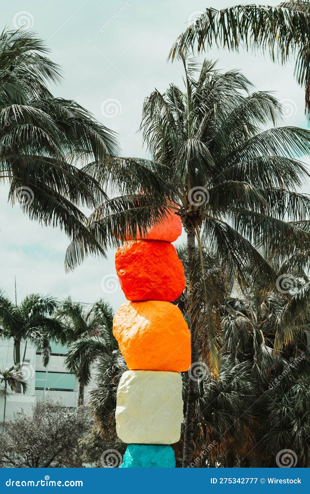 Stack of Vibrant Colored Rocks Against a Backdrop of a Palm Trees Stock ...