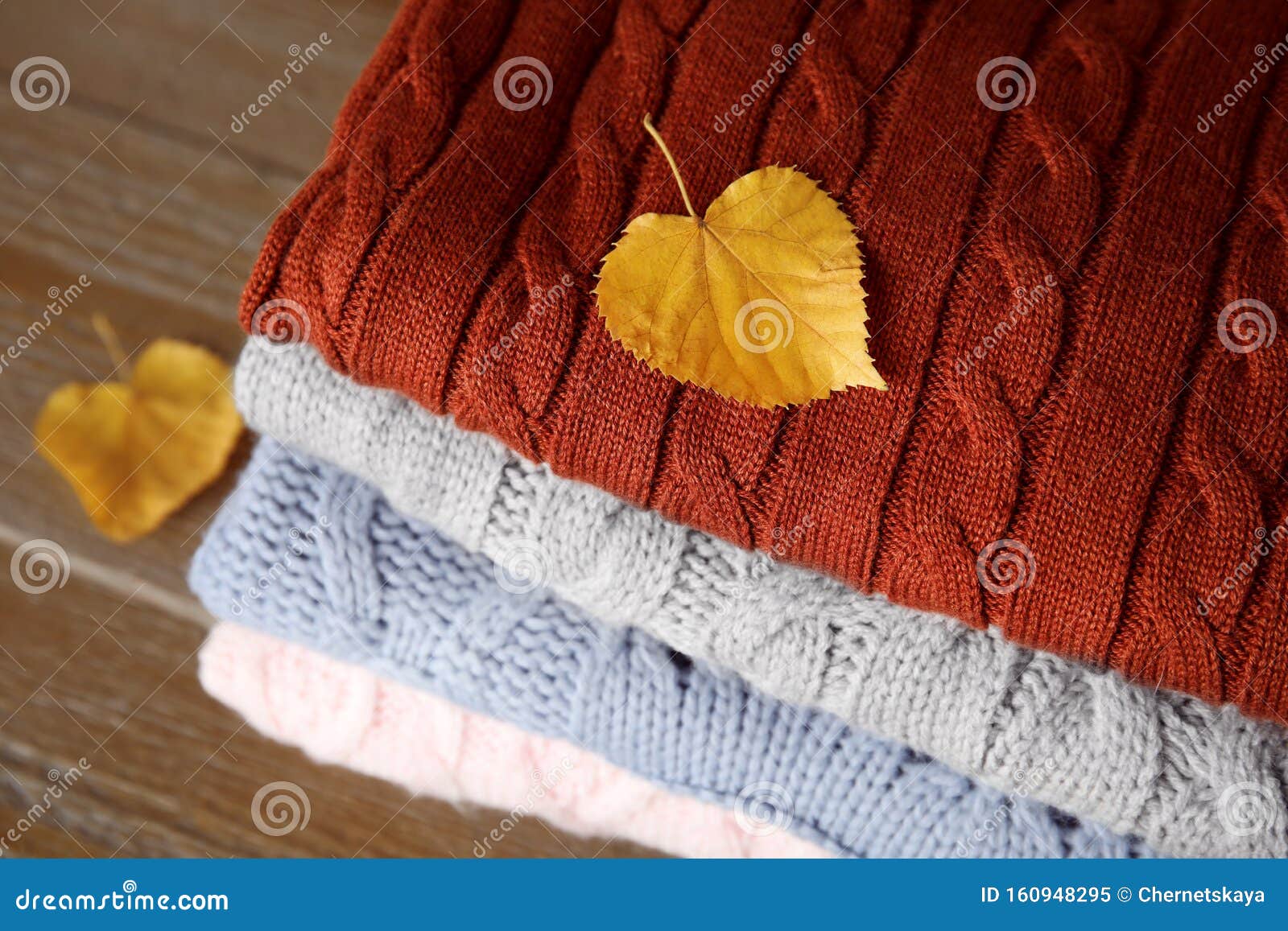 Stack of Warm Knitted Clothes and Autumn Leaves on Background, Above ...