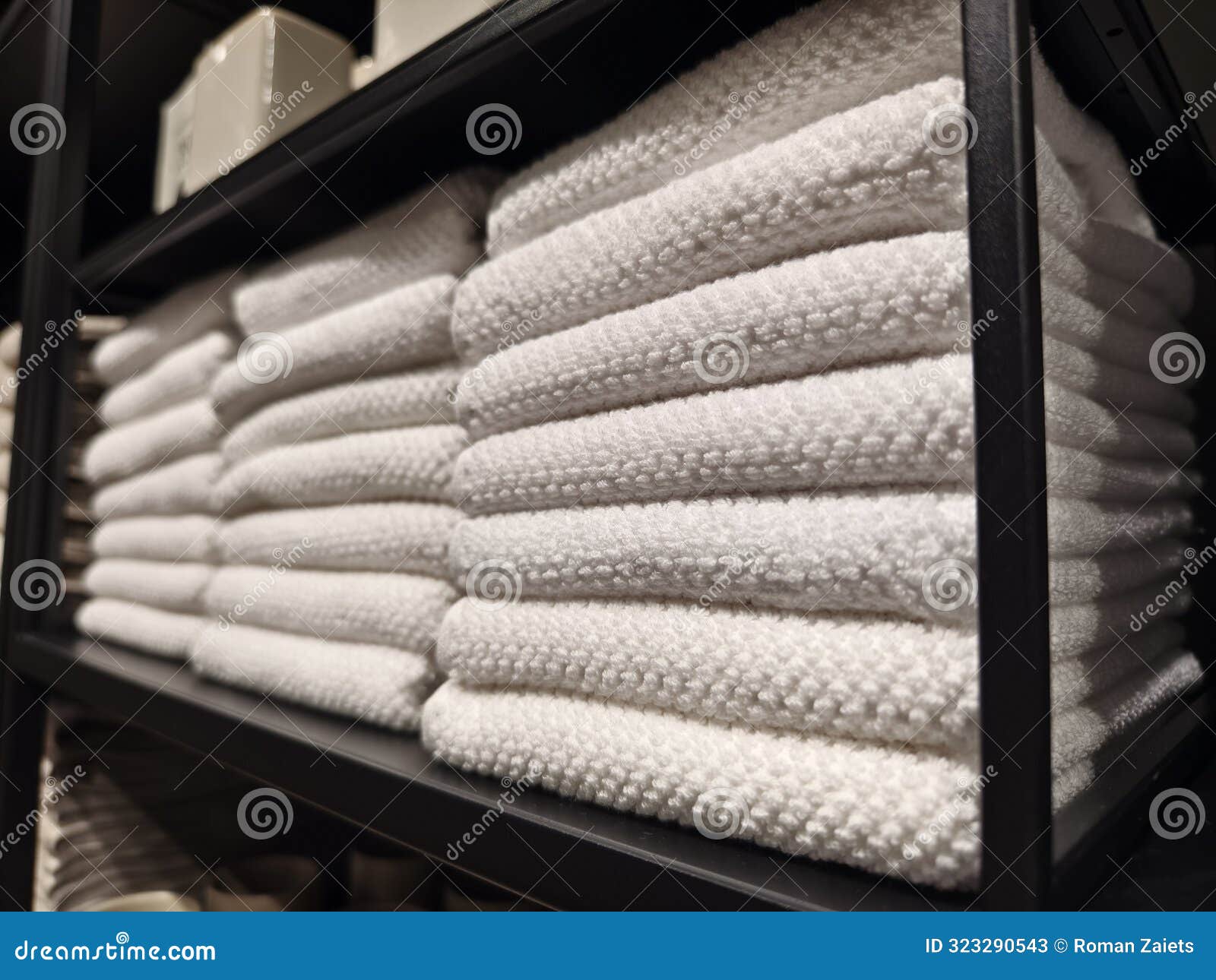 A Stack of White Towels Neatly Arranged on a Black Shelf Stock Image ...
