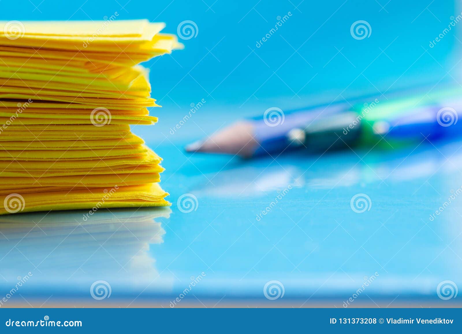 A Stack of Yellow Paper and a Pencil on a Blue Table Close-up. Stock ...