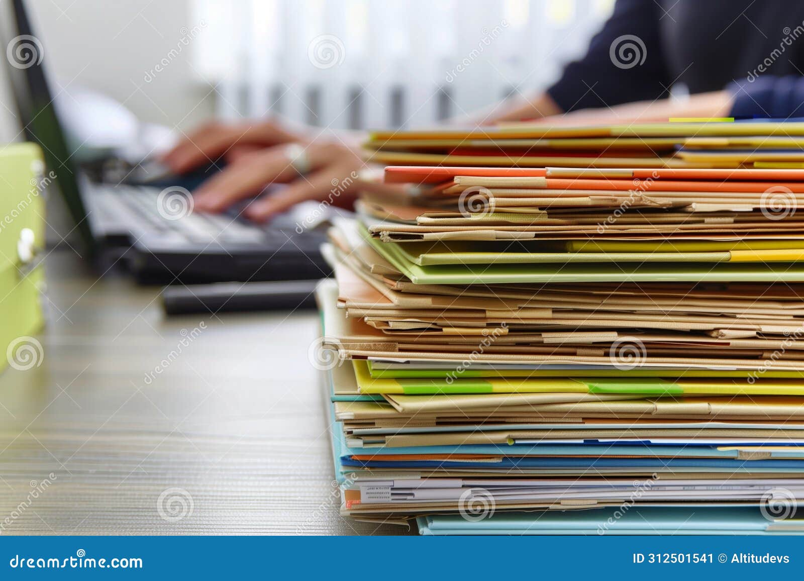 Stacked Files on a Desk with a Blurred Figure Typing on a Keyboard ...