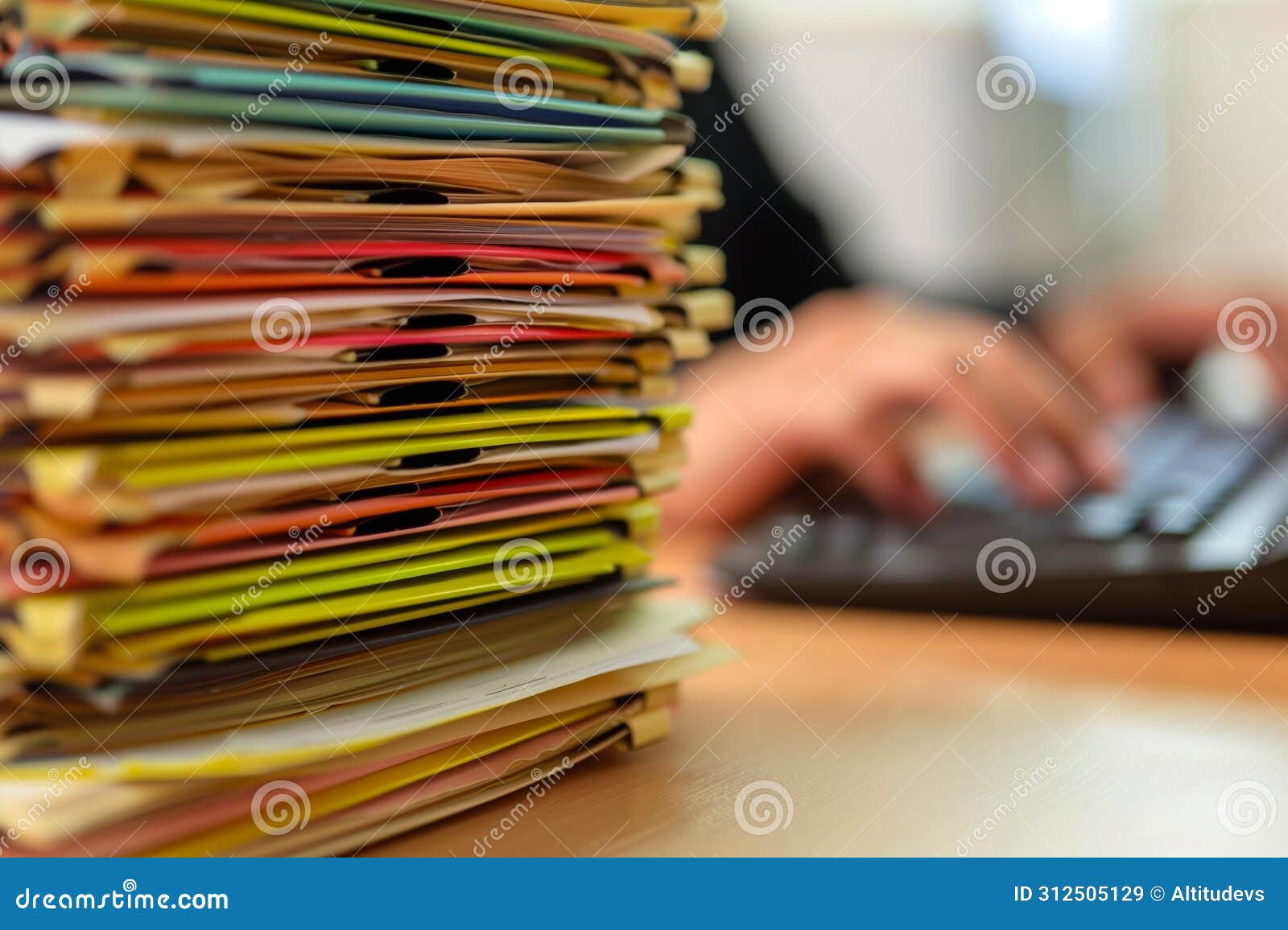 Stacked Files on a Desk with a Blurred Figure Typing on a Keyboard ...