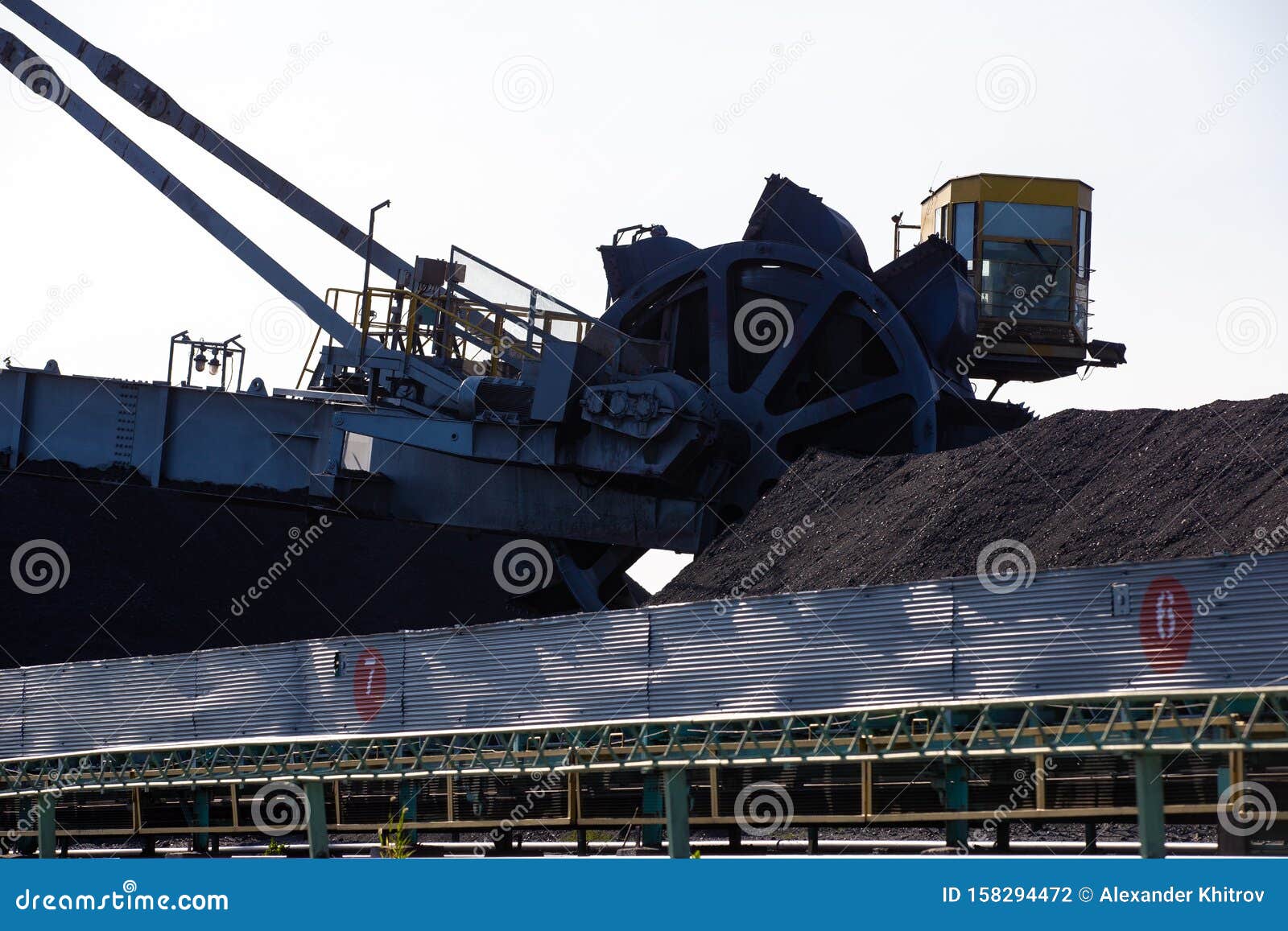 Stacker-reclaimer during Loading and Unloading of Coal. Coal Heaps at a ...