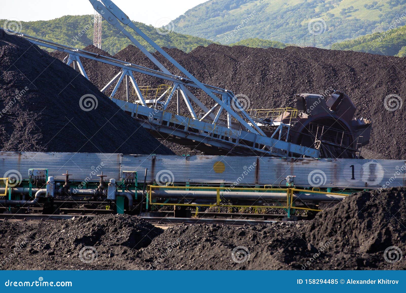 Stacker-reclaimer during Loading and Unloading of Coal. Coal Heaps at a ...