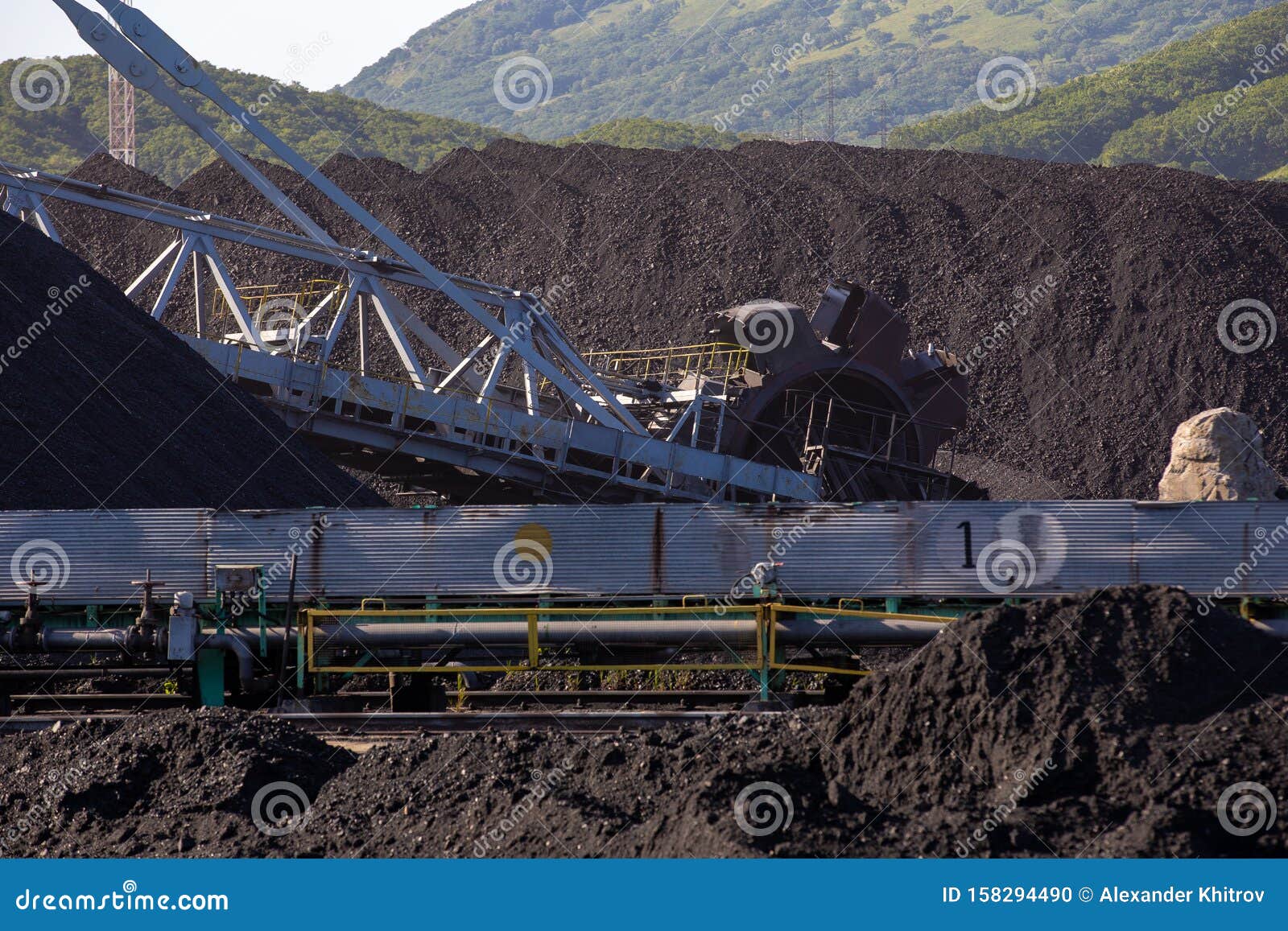 Stacker-reclaimer during Loading and Unloading of Coal. Coal Heaps at a ...