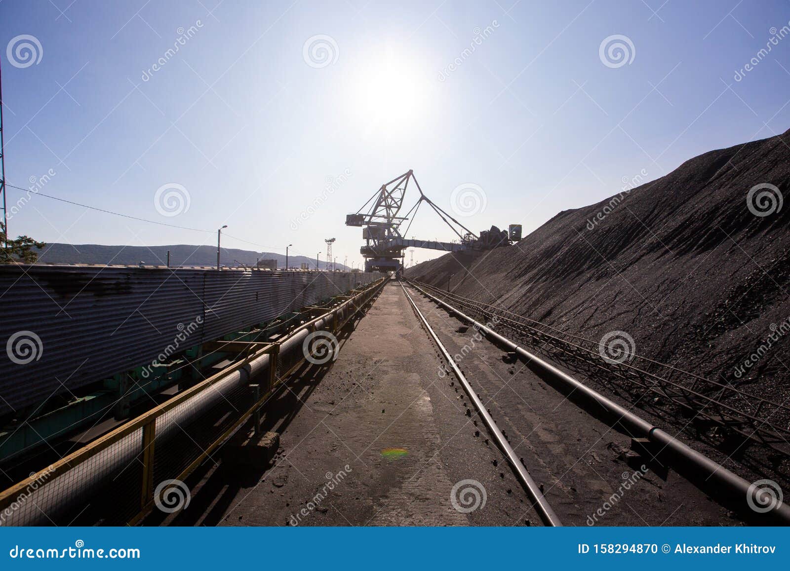 Stacker-reclaimer during Loading and Unloading of Coal. Coal Heaps at a ...